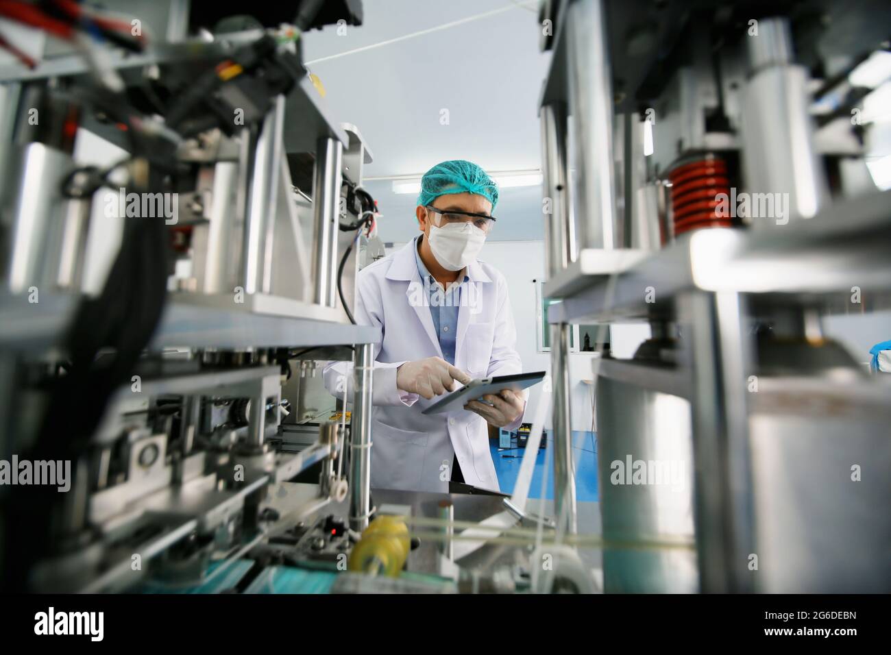Quality control worker analyzing manufacturing machine in laboratory ...