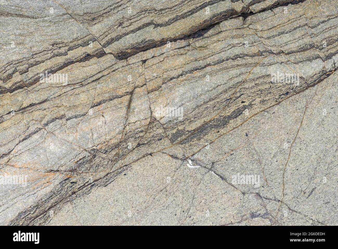 Low tide reveals linear patterns in the rock at the base of a sea stack ...