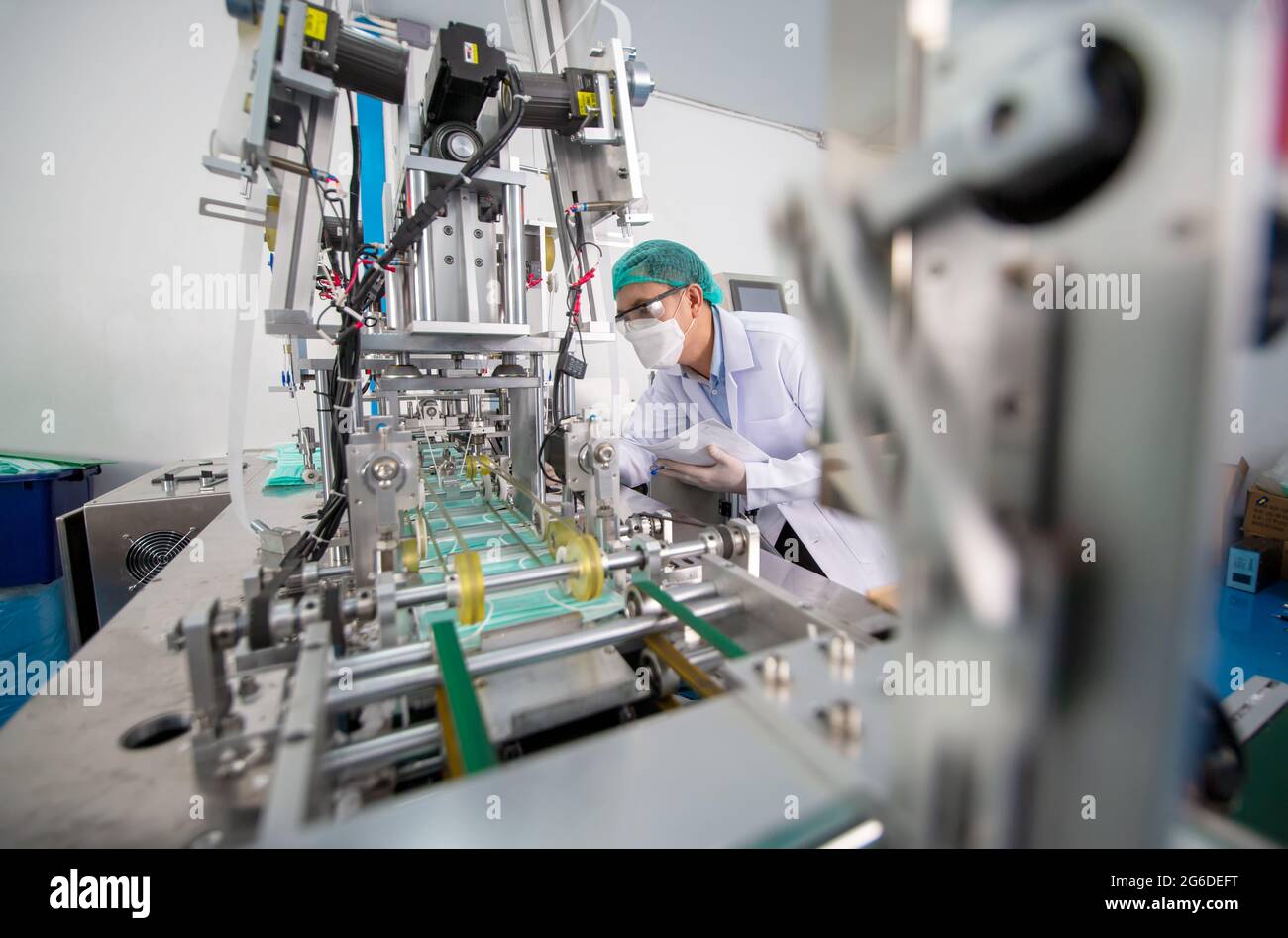 Quality control worker analyzing manufacturing machine in laboratory ...