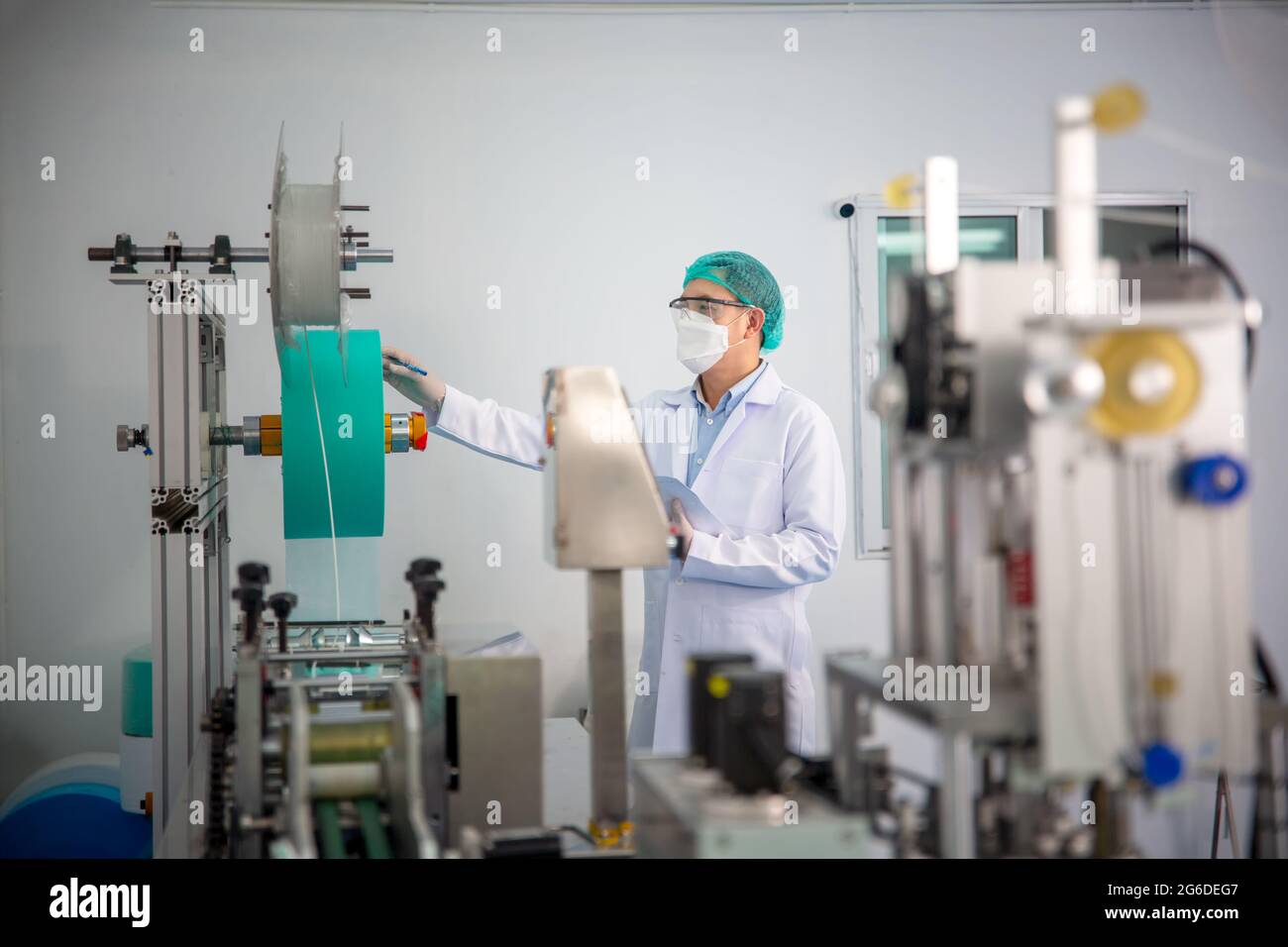 Quality control worker analyzing manufacturing machine in laboratory ...