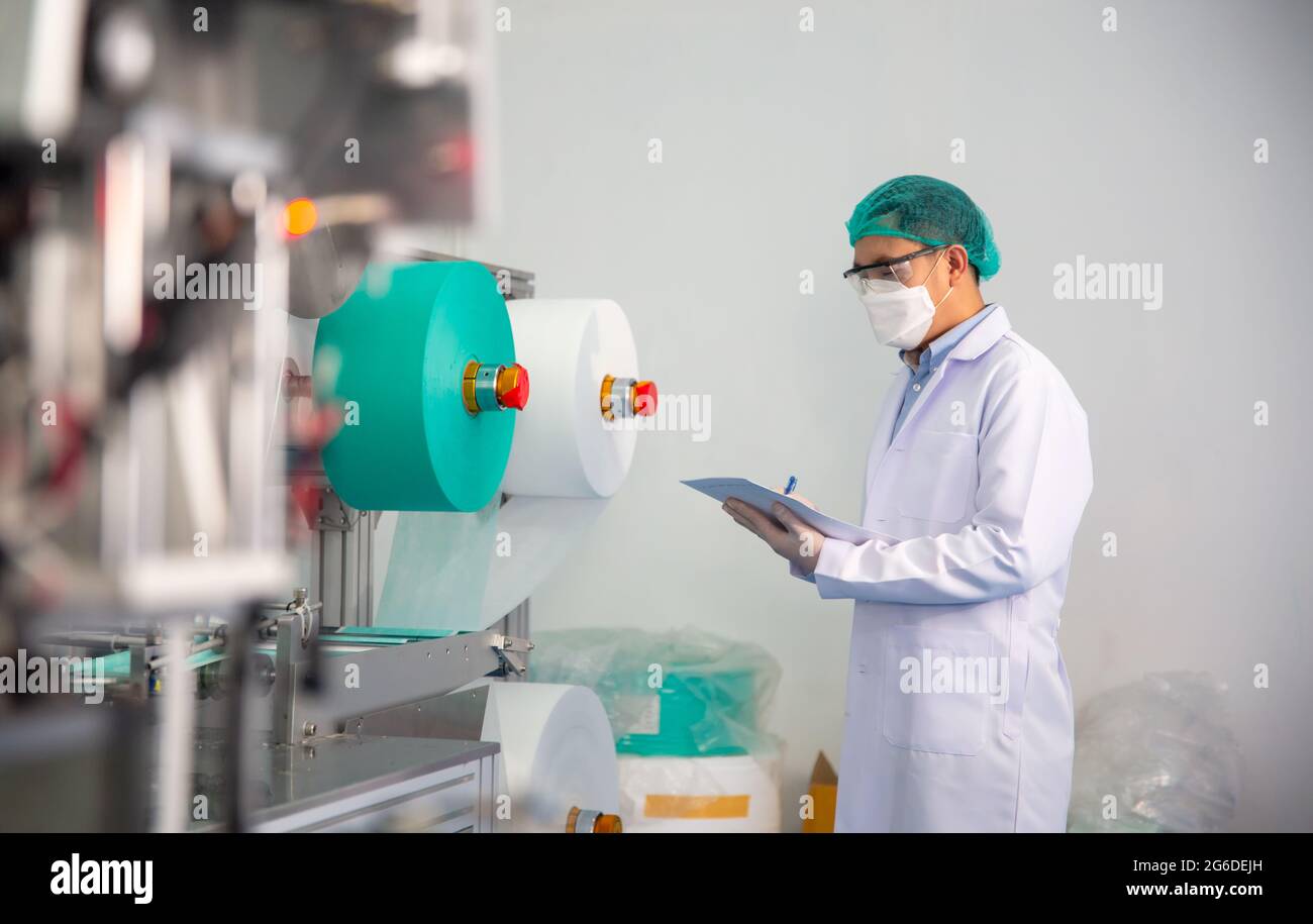 Quality control worker analyzing manufacturing machine in laboratory ...