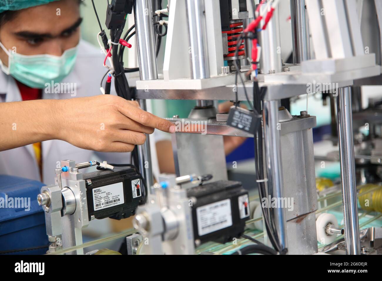 Quality control worker analyzing manufacturing machine in laboratory ...