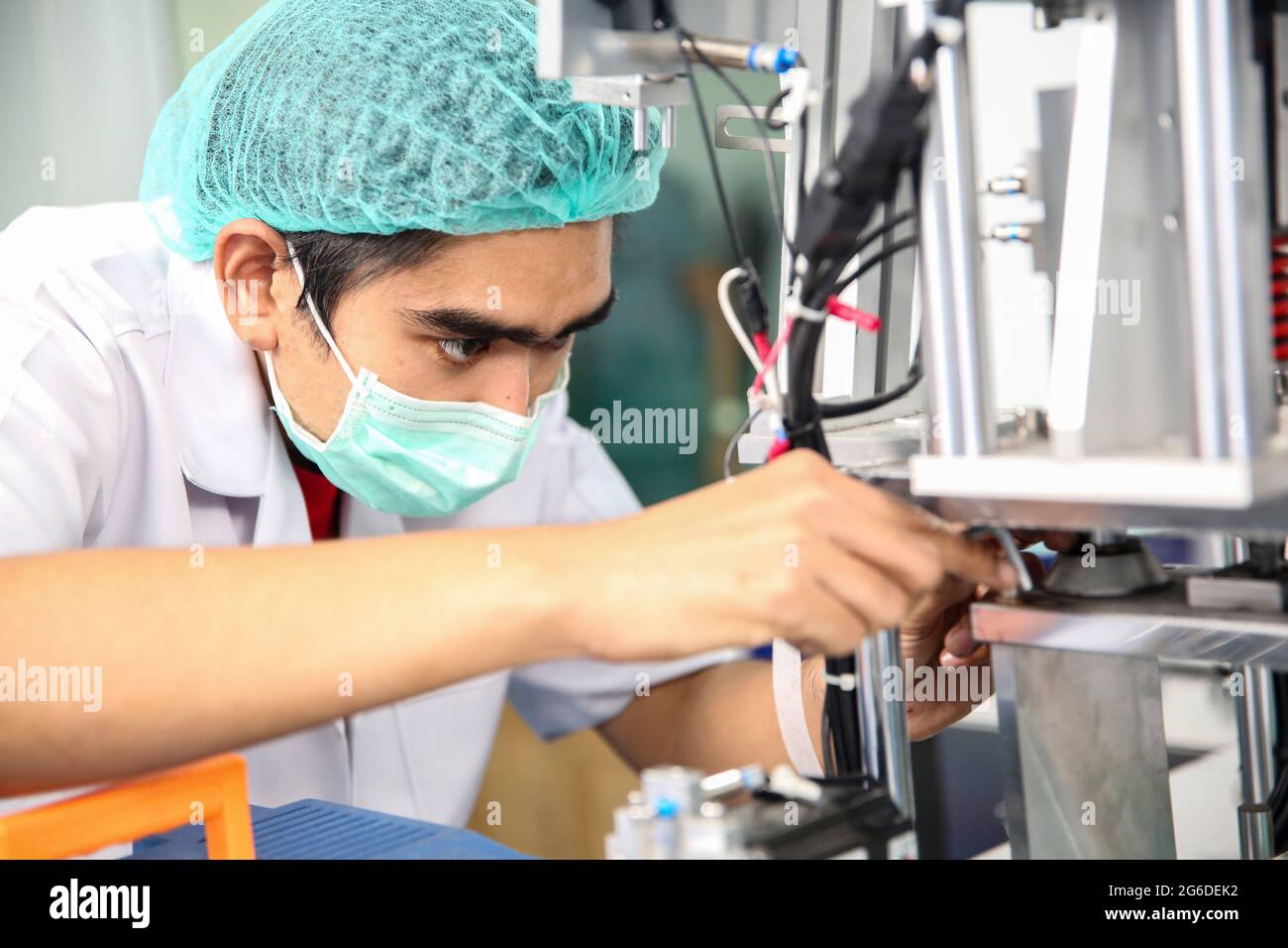 Quality control worker analyzing manufacturing machine in laboratory ...