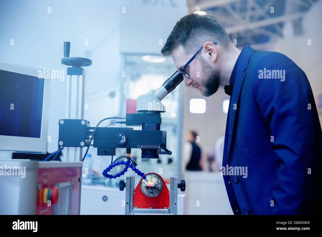 Industrial worker use microscope for precision plasma welding at modern ...
