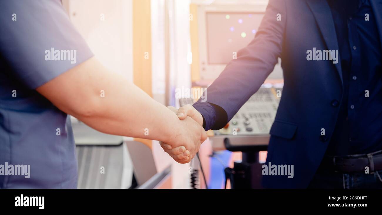 Worker engineer shaking hands with businessman at construction site ...