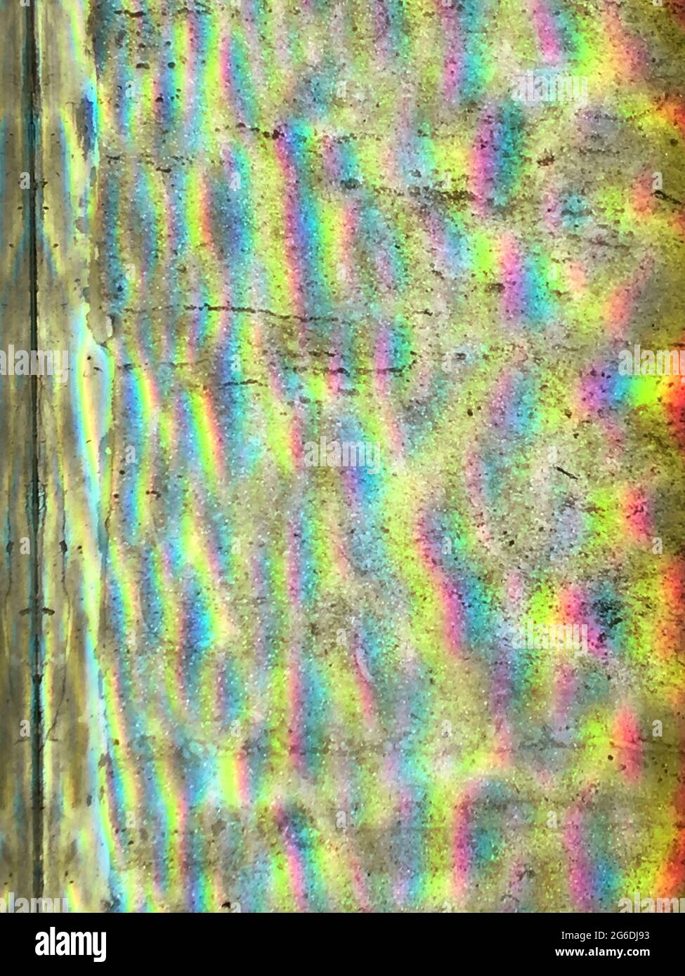 Rainbow lights through glass and water hits the concrete floor.Seeing ...