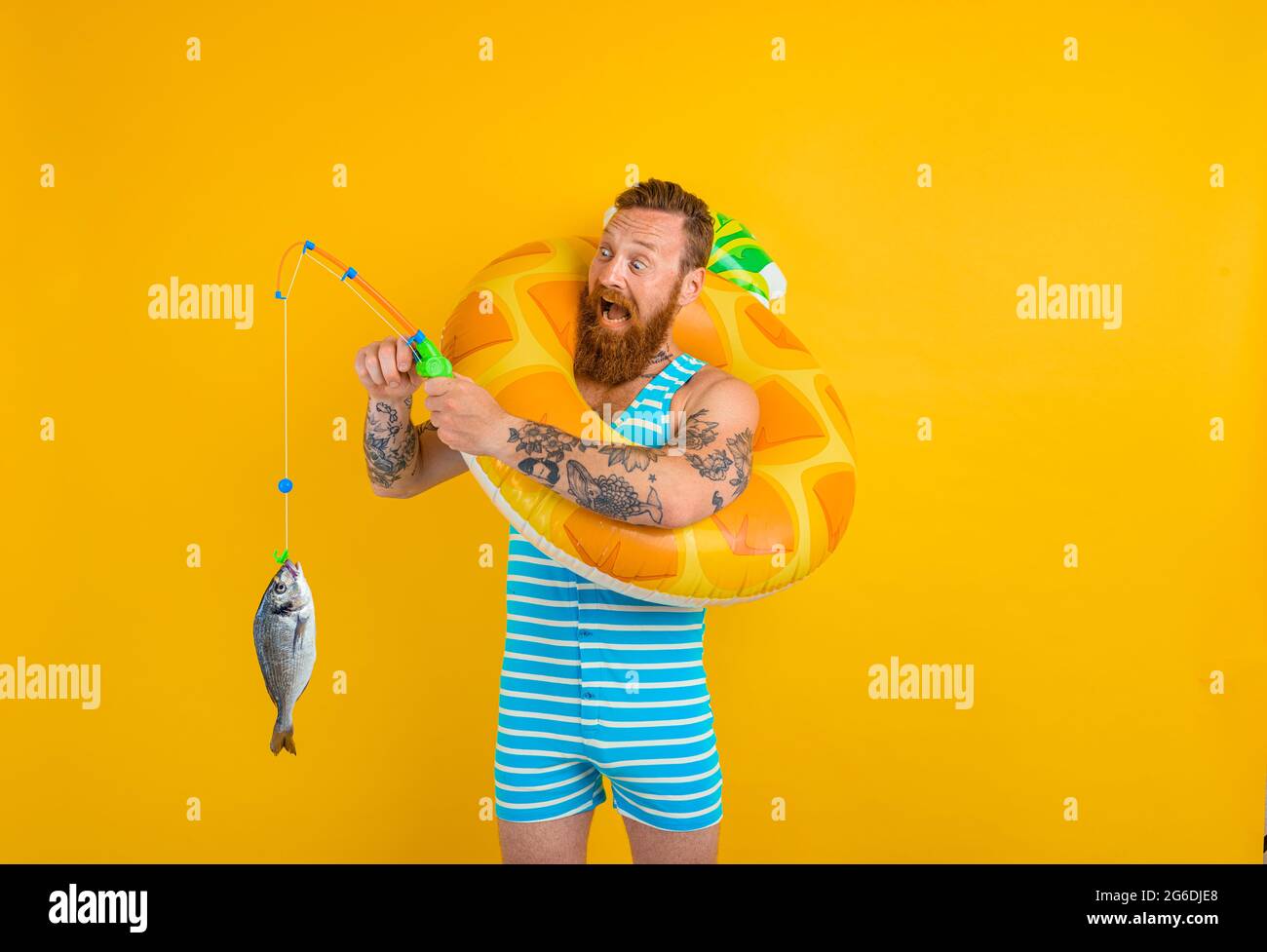 Man with beard and inflatable donut catches fish Stock Photo - Alamy