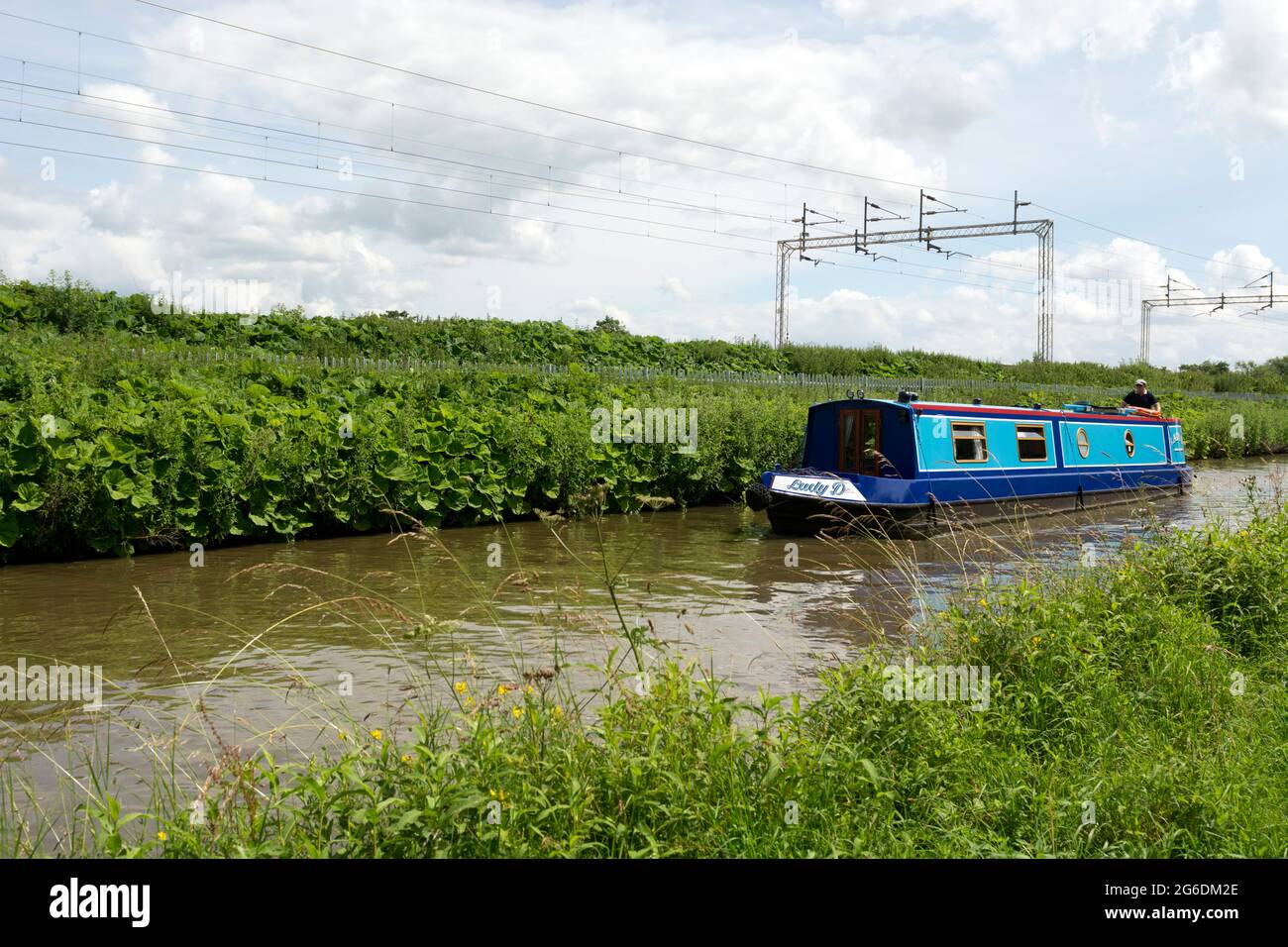 A narrowboat on the Oxford Canal alongside the West Coast Main Line ...