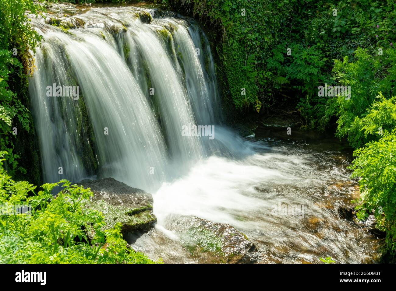 Long exposure of a waterfall flowing onto Lee Abbey Beach in Devon ...