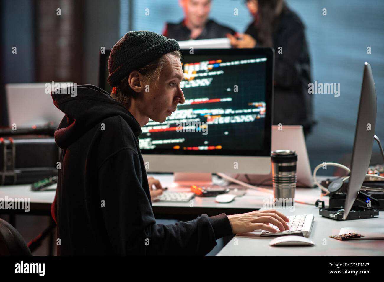 Busy young man using two computers simultaneously Stock Photo - Alamy