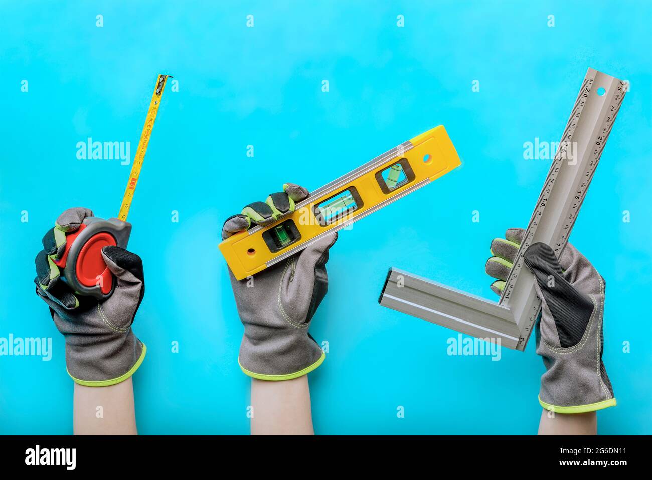 Tools in hand. Hands hold construction and carpentry tools, on a blue ...