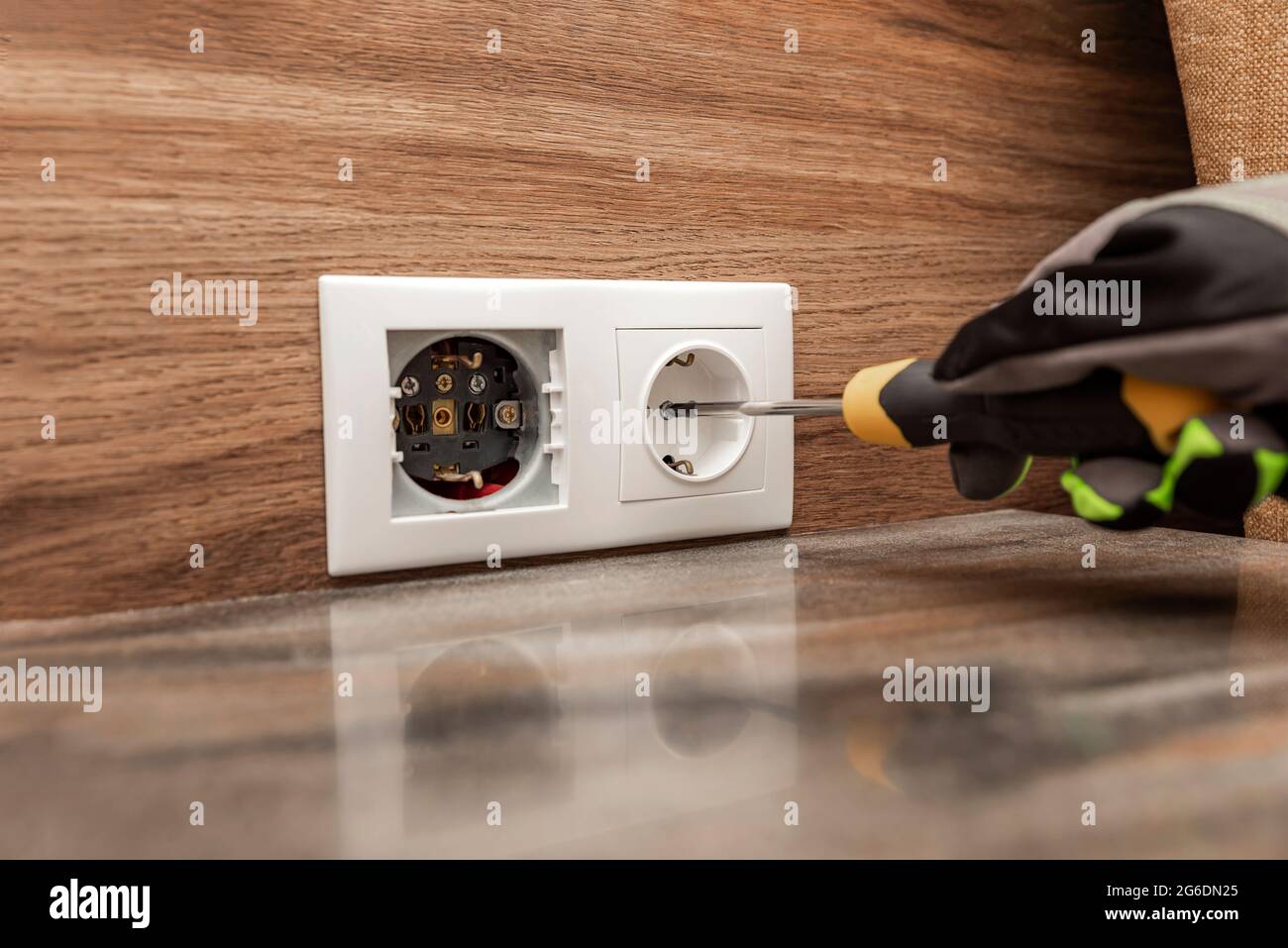 The electrician installs a decorative frame on the electrical outlets ...