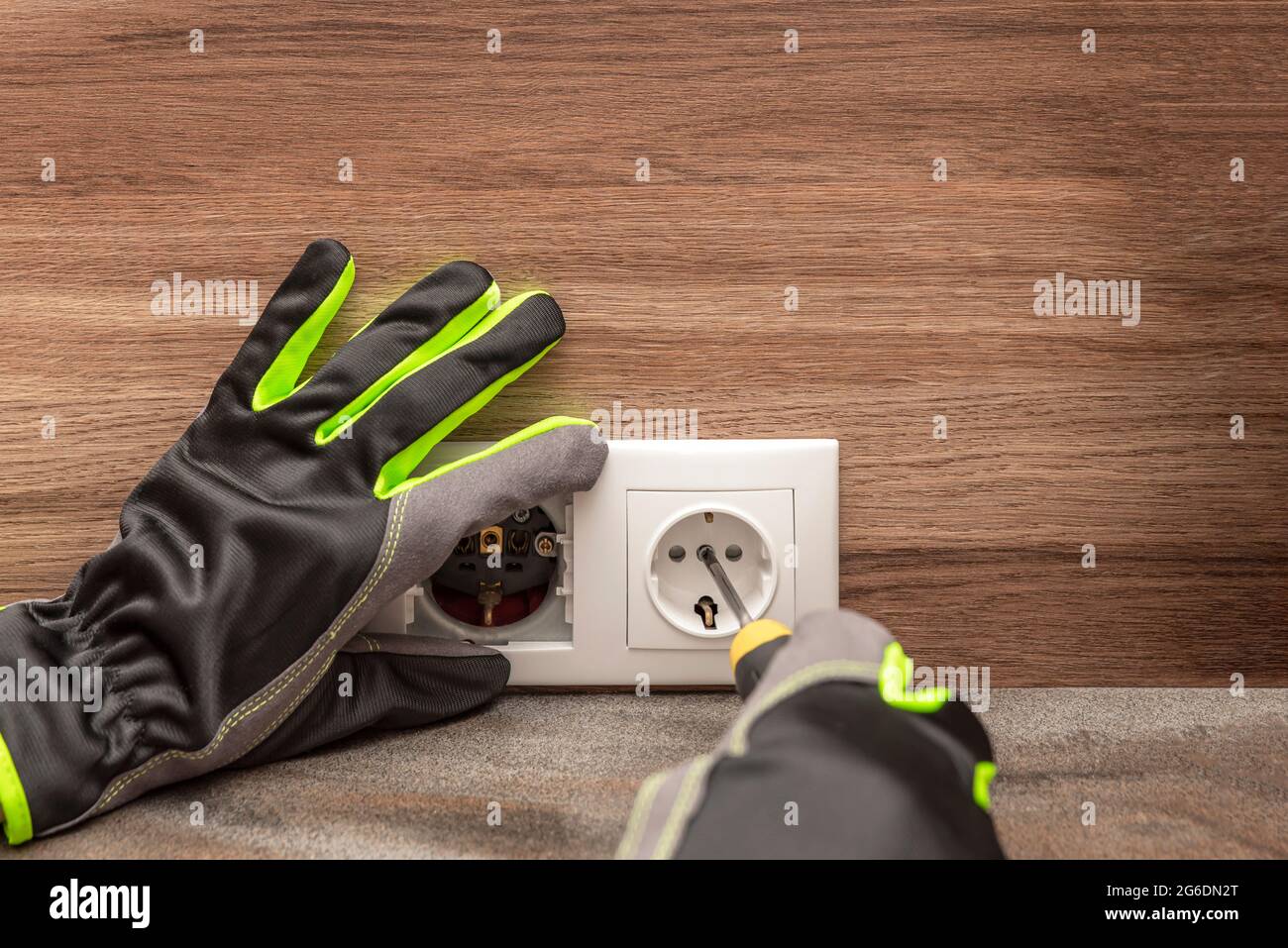 The electrician installs a decorative frame on the electrical outlets ...