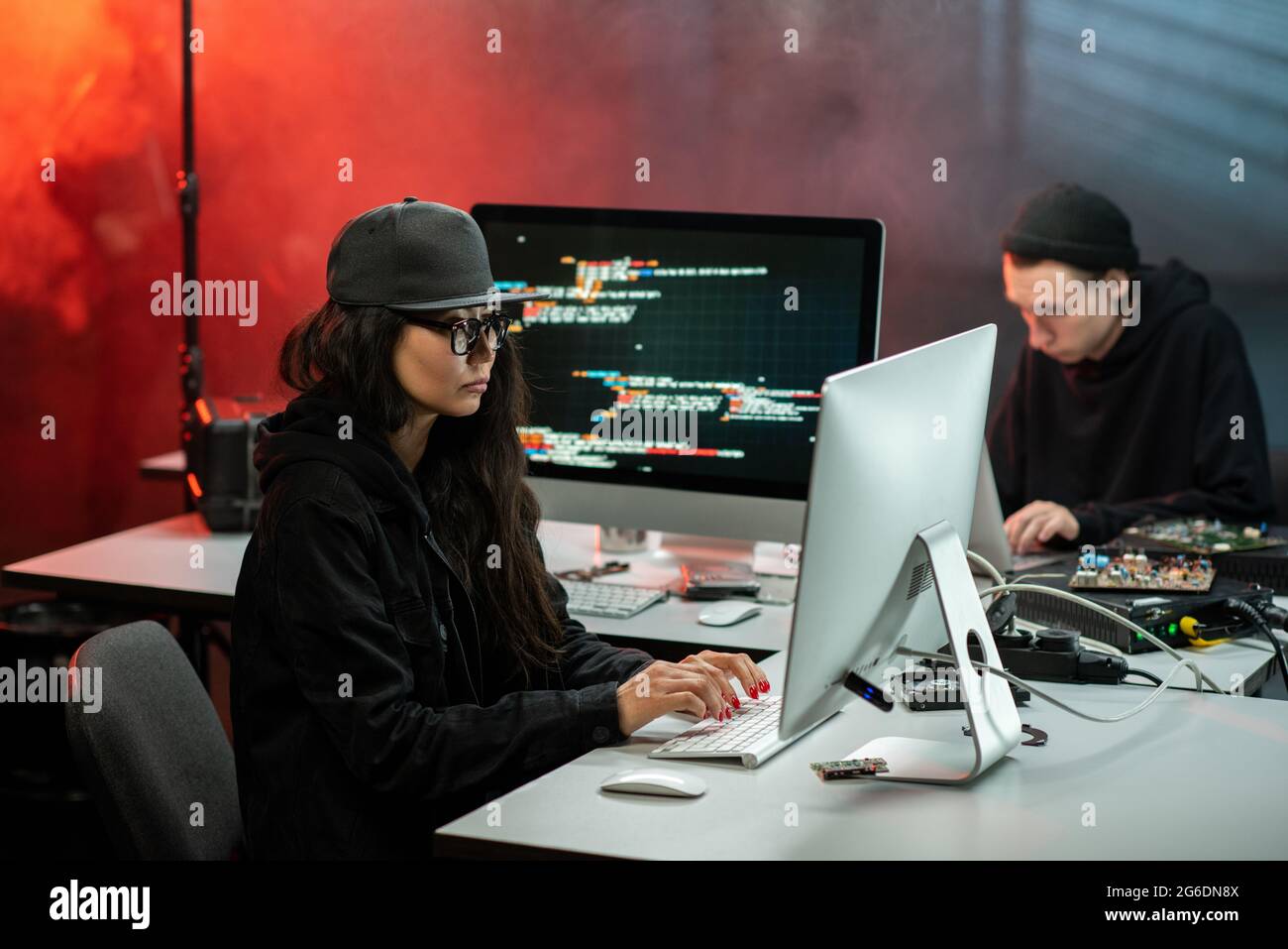 Female hacker looking at computer screen while decoding data Stock Photo - Alamy
