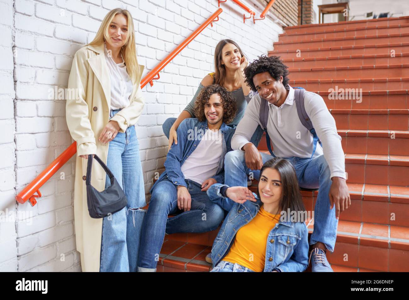 Group of friends with ethnic variety, sitting on some street steps ...