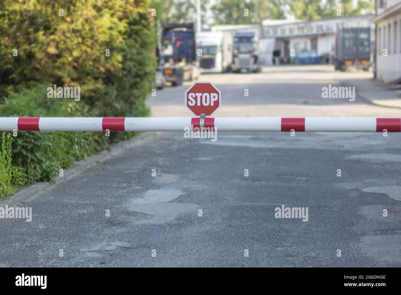 Barrier and stop sign on the road. Entrance to organization gate ...