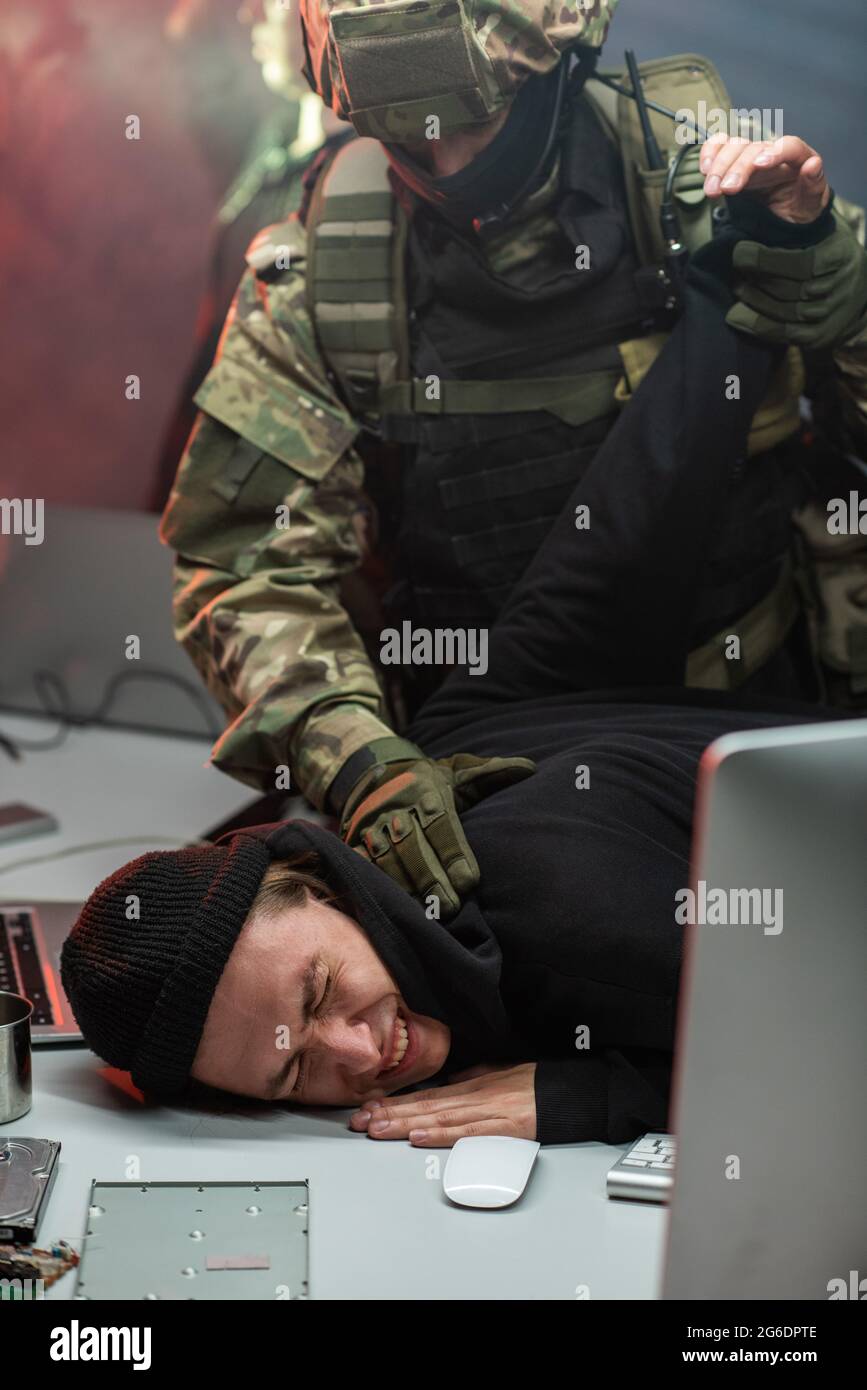 Police officer in military uniform seizing one of cyber criminals Stock ...