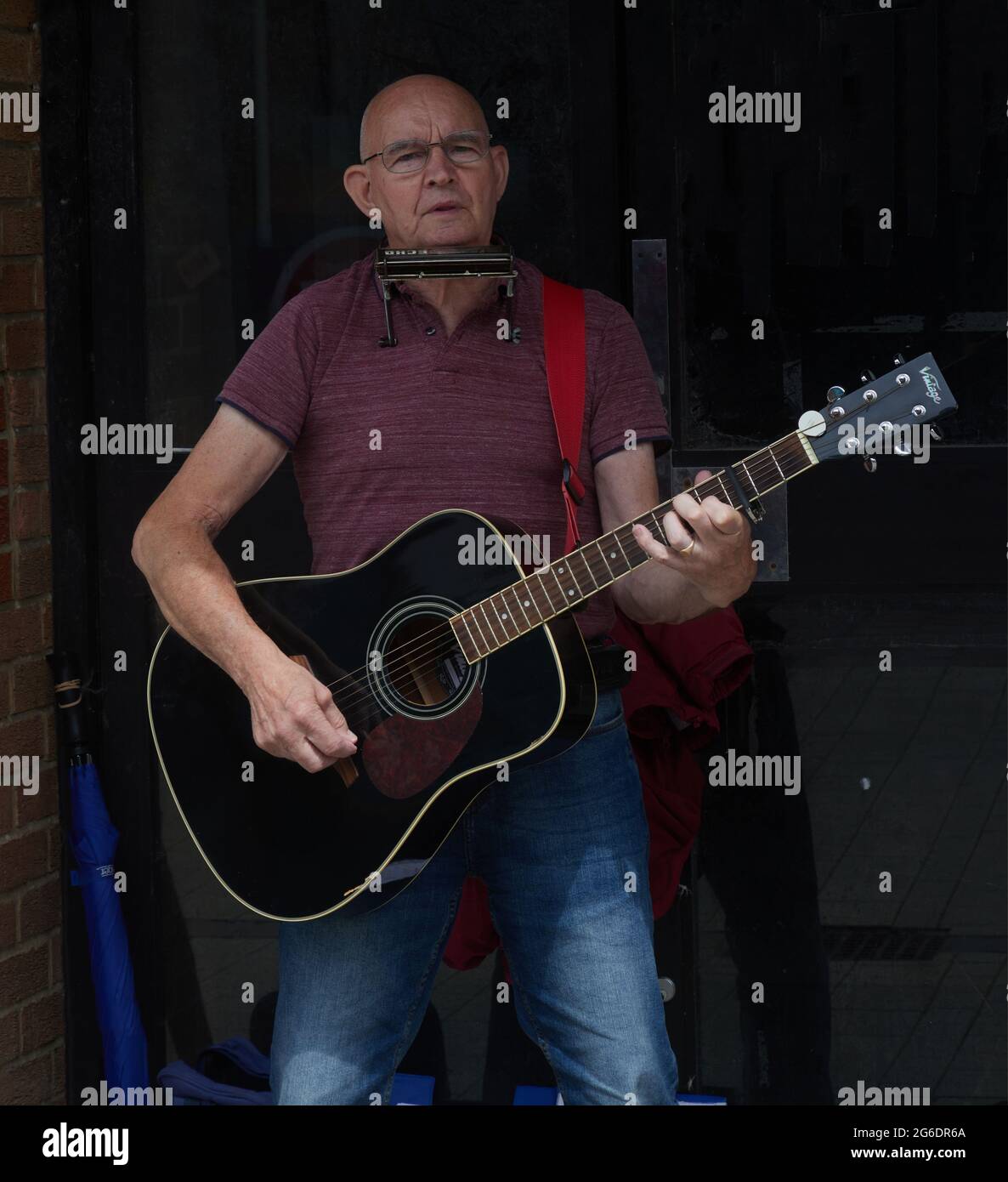 Senior citizen seen busking whilst palying the guitar and singing Stock ...