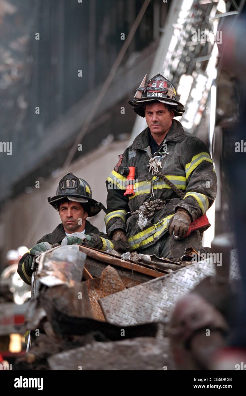 Firefighters look on Friday, Sept. 14, 2001, as President George W ...