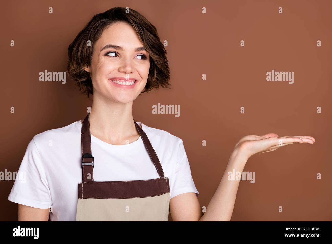 Photo of charming lady look arm palm hold demonstrate empty space offer ...