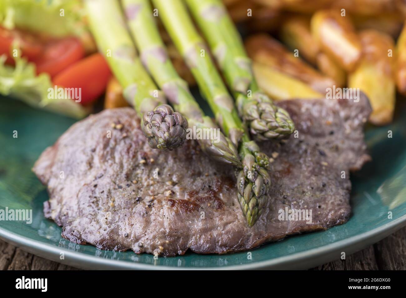 asparagus on a grilled steak with fries Stock Photo - Alamy