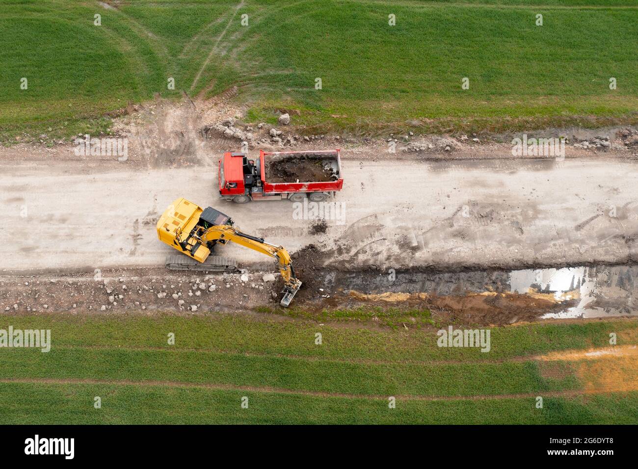 Excavator digging ground near the field and loading to the truck Stock ...