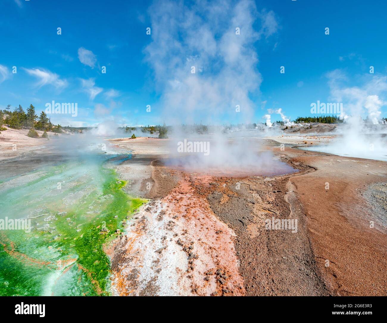 Red mineral deposits and green algae at a thermal spring, steaming hot ...