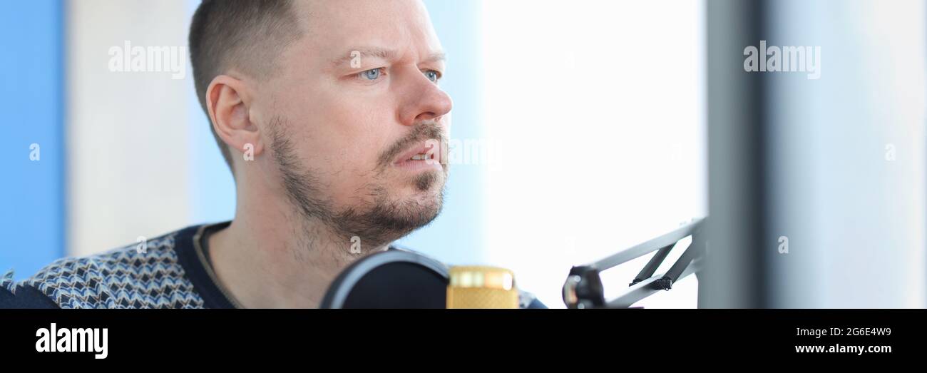 Young man sitting in front of microphone in recording studio Stock ...