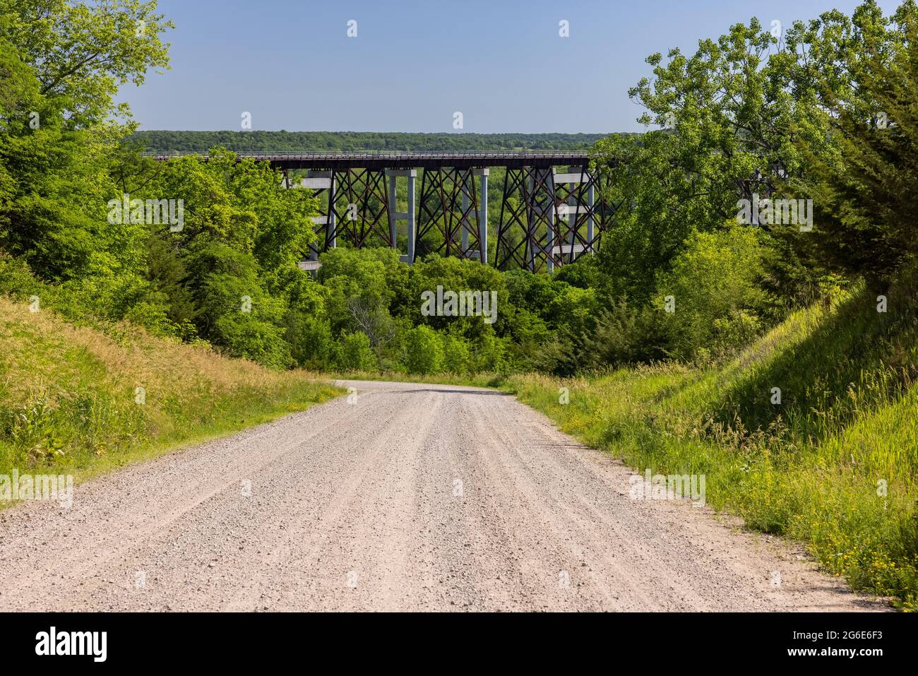 A gravel road leading to a railroad high trestle bridge Stock Photo - Alamy