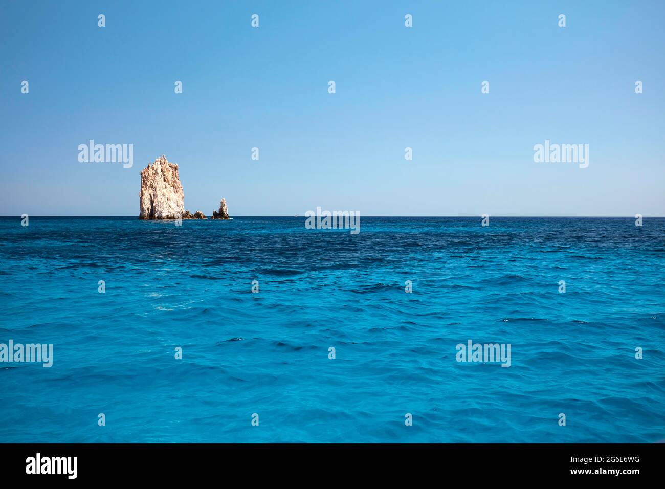 Rock needle in the blue water off the coast of Polyaigos next to Milos ...