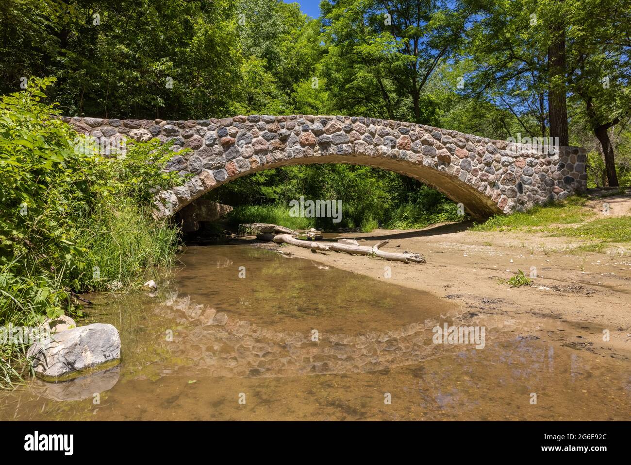 Stone Arch Footbridge Over A Creek Stock Photo - Alamy