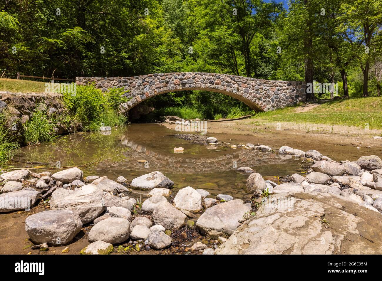 Stone Arch Footbridge Over A Creek Stock Photo - Alamy