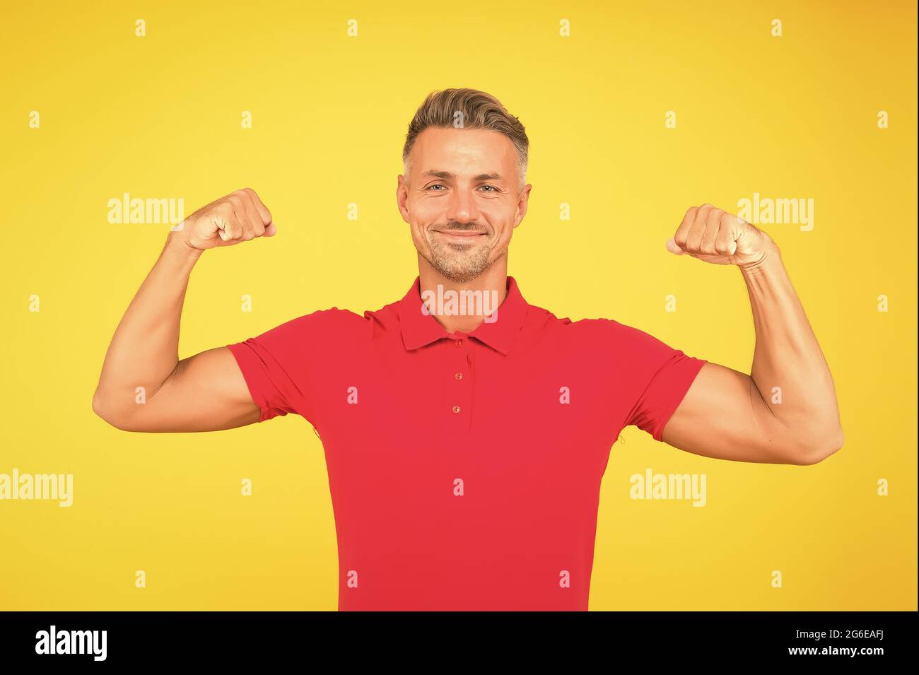 Strong athletic guy smile in red tshirt flexing muscular arms yellow ...