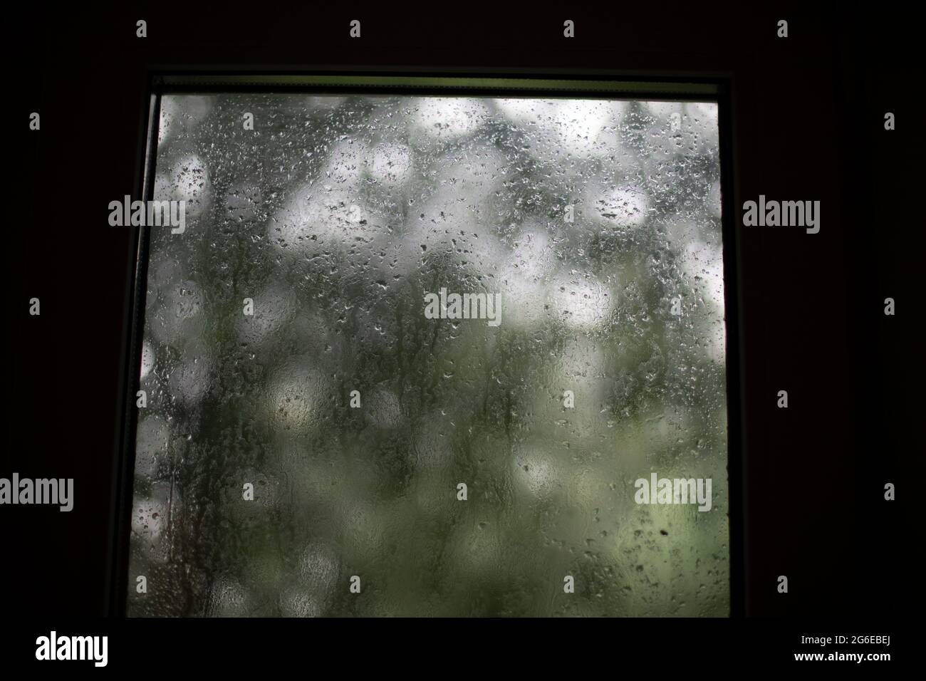 A wet window. It's a rainy day. The glass is covered with water. Bad ...