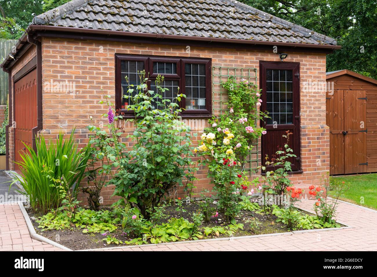 A typical suburban front garden with a double garage and rose garden ...