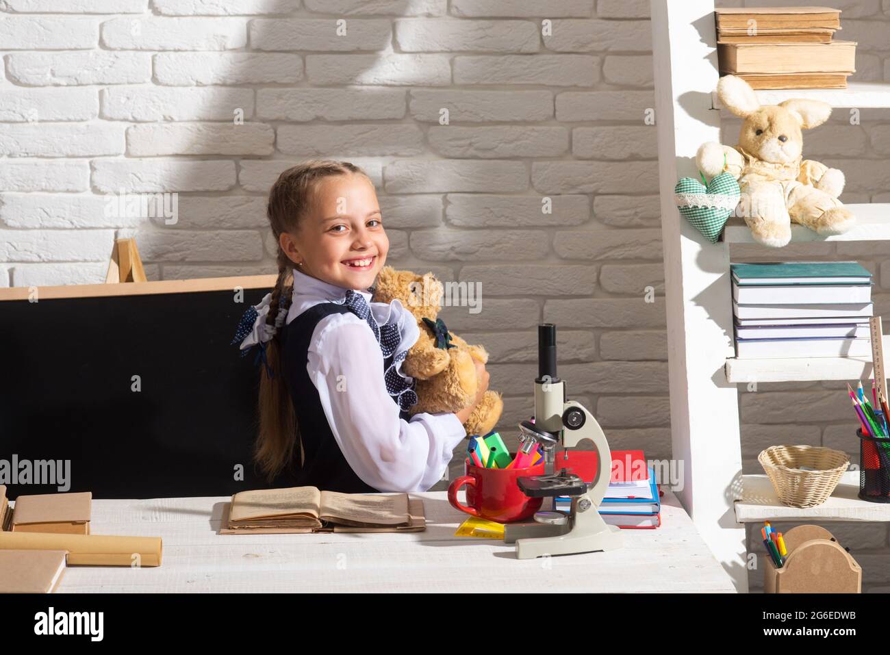 School kid girl hold toy teddy bear. Child is learning in class. Pupil ...