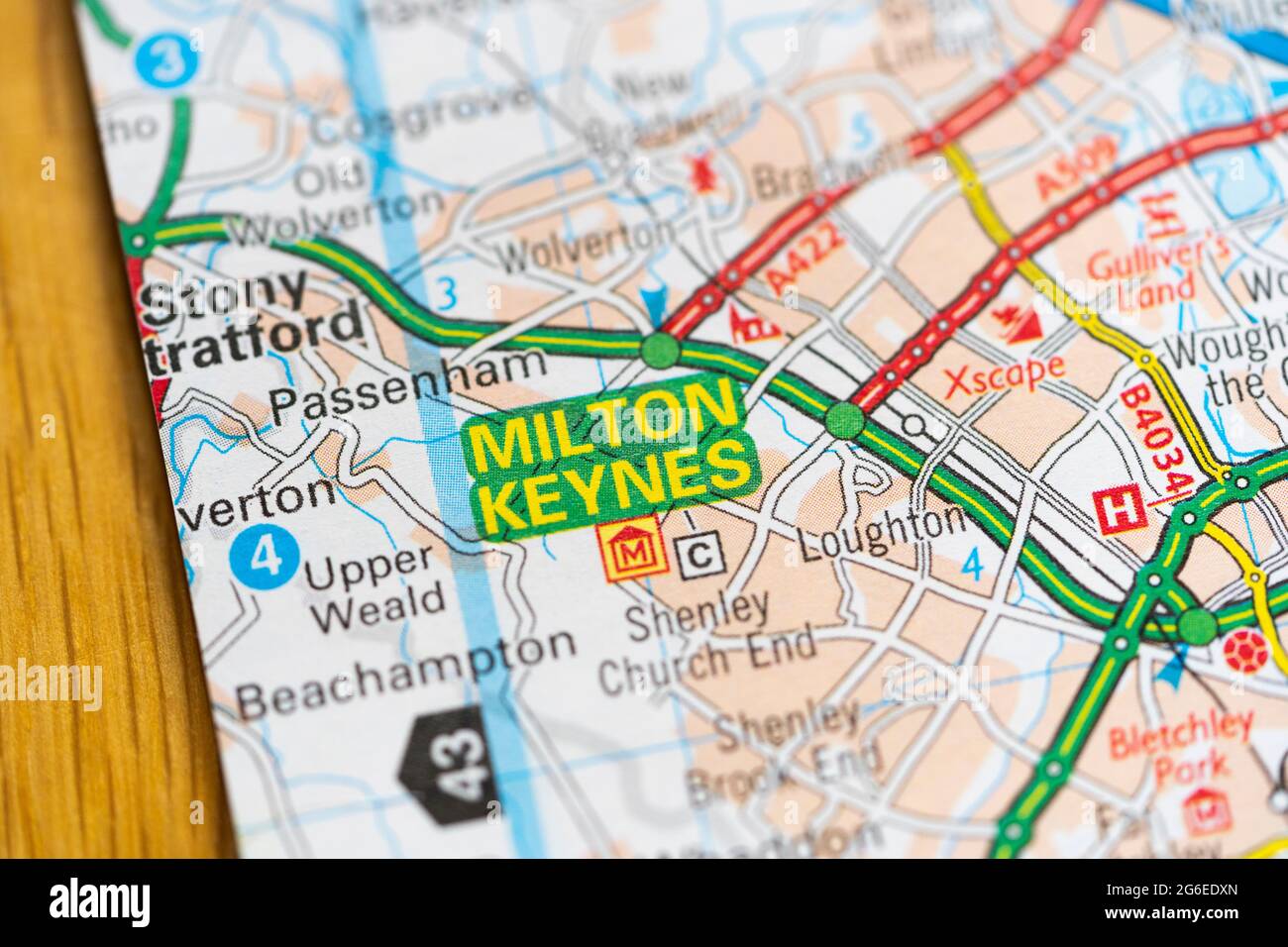 A macro closeup of a page in a printed road map atlas showing the new town of Milton Keynes in ...