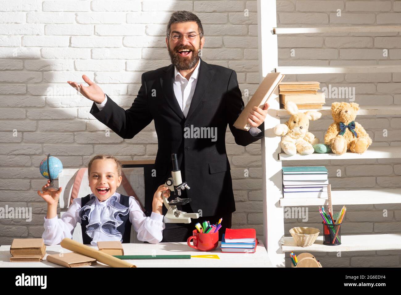 Excited teacher with funny happy school girl in school lesson. Happy ...