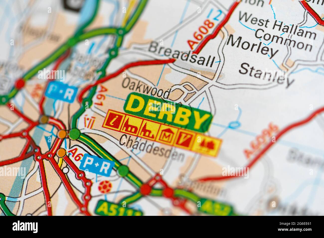 A macro closeup of a page in a printed road map atlas showing the city ...