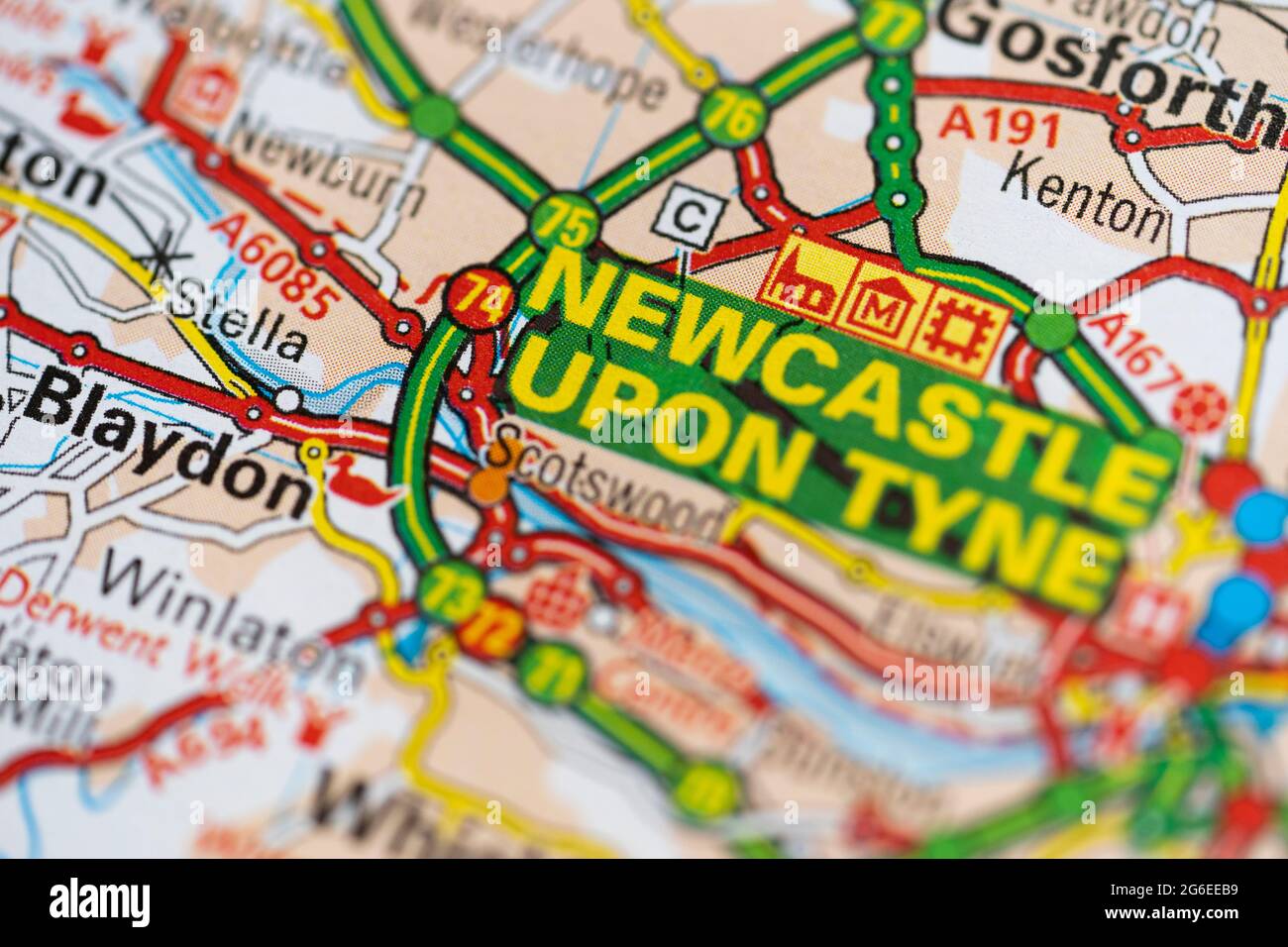 A macro closeup of a page in a printed road map atlas showing the city ...