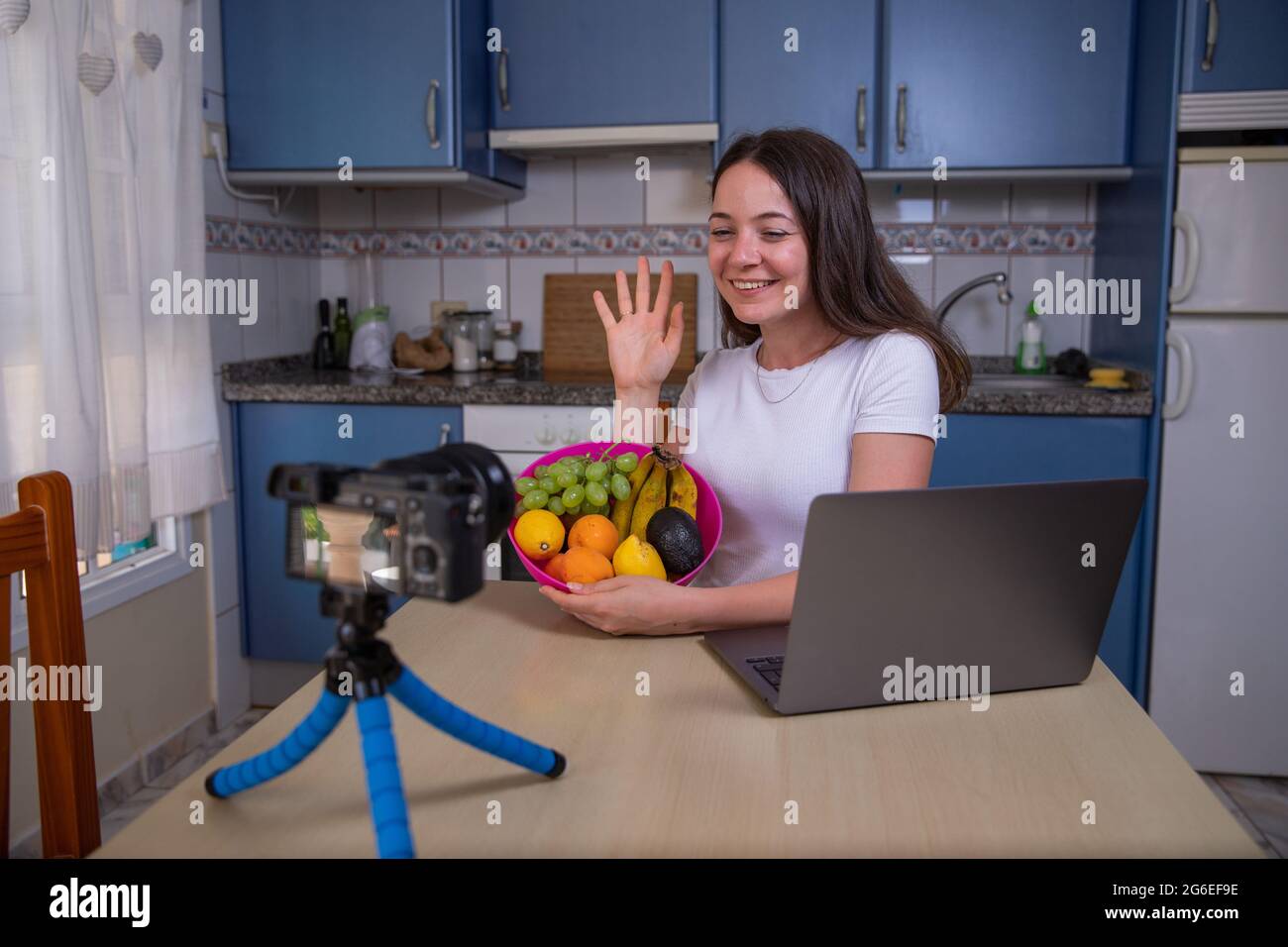 Young female blogger films herself with a basket fruit. Beautiful ...