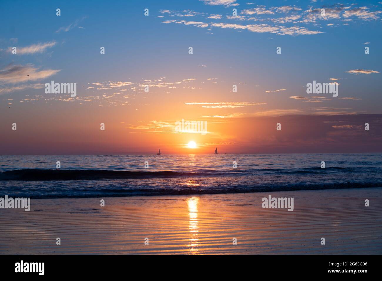 Calm sea with sunset sky and sun through the clouds over. Ocean and sky ...