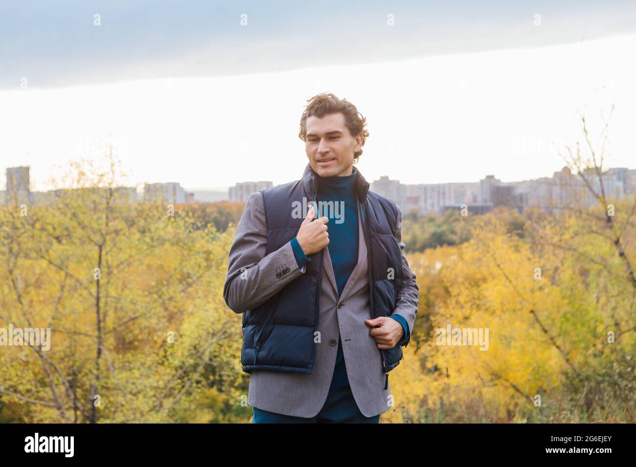 Tall handsome man walking outdoor in yellow autumn forest on the hill ...