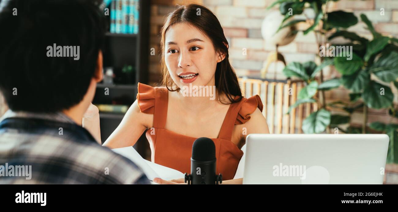 Cheerful young Asian female podcaster holding a questionnaire while ...