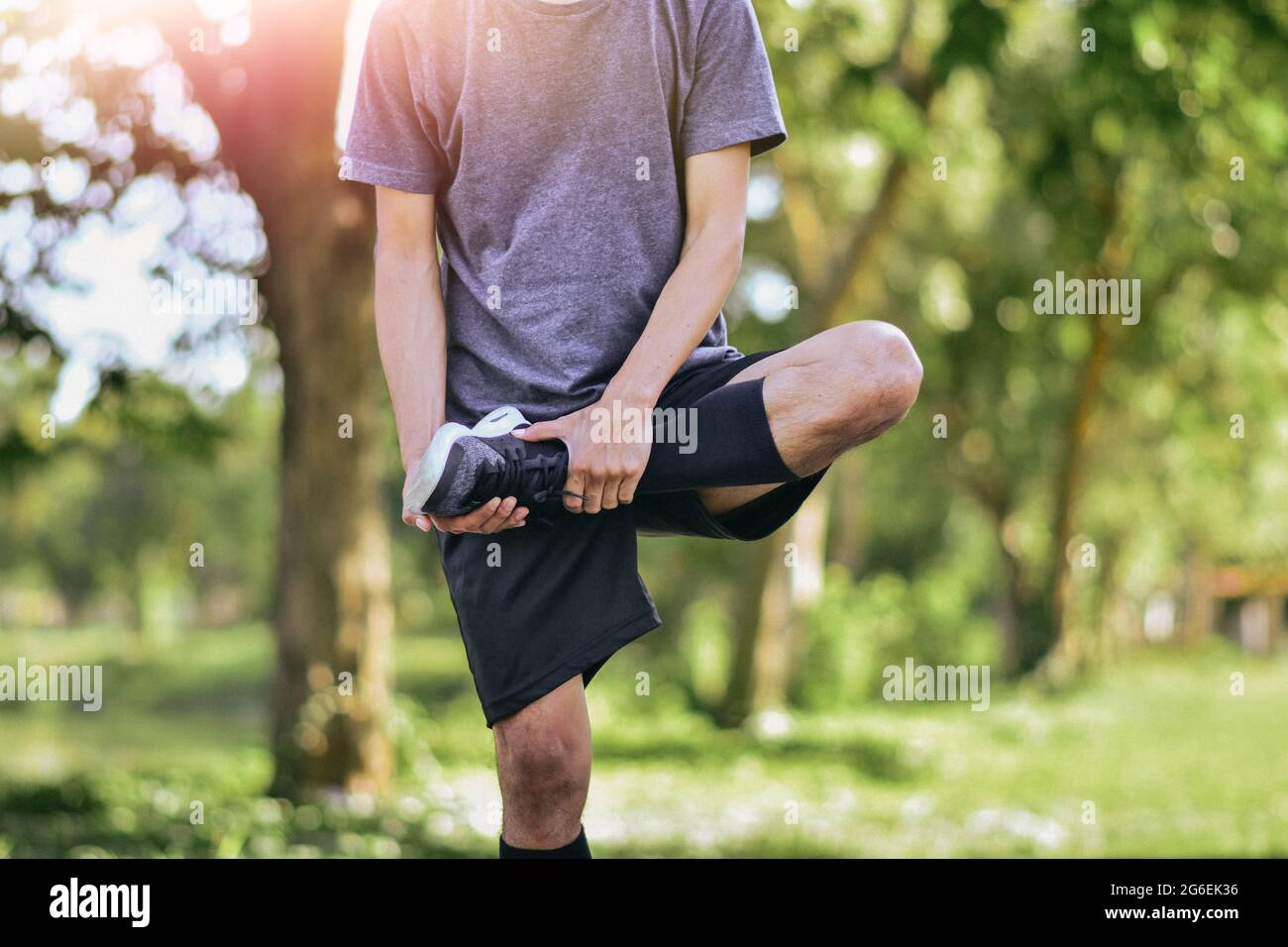 man stretching his leg muscles before exercising, Young male jogger ...