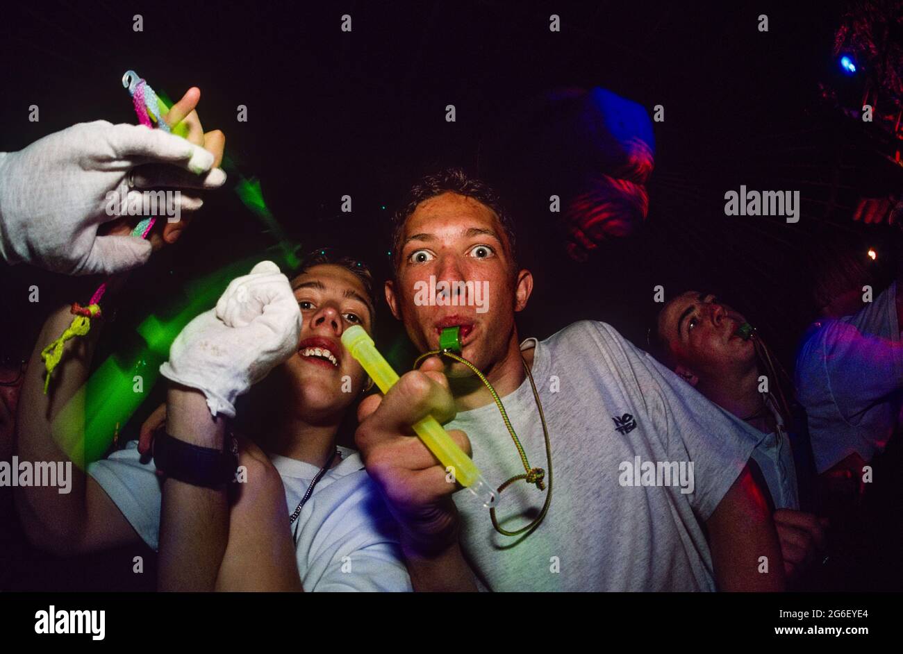 A young man dancing holding glow sticks at, Tribal Gathering an all ...