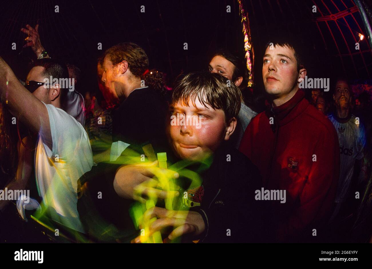 A young man dancing holding glow sticks at, Tribal Gathering an all ...
