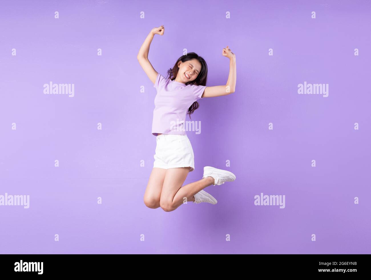 Young asian girl jumping up on purple background Stock Photo - Alamy