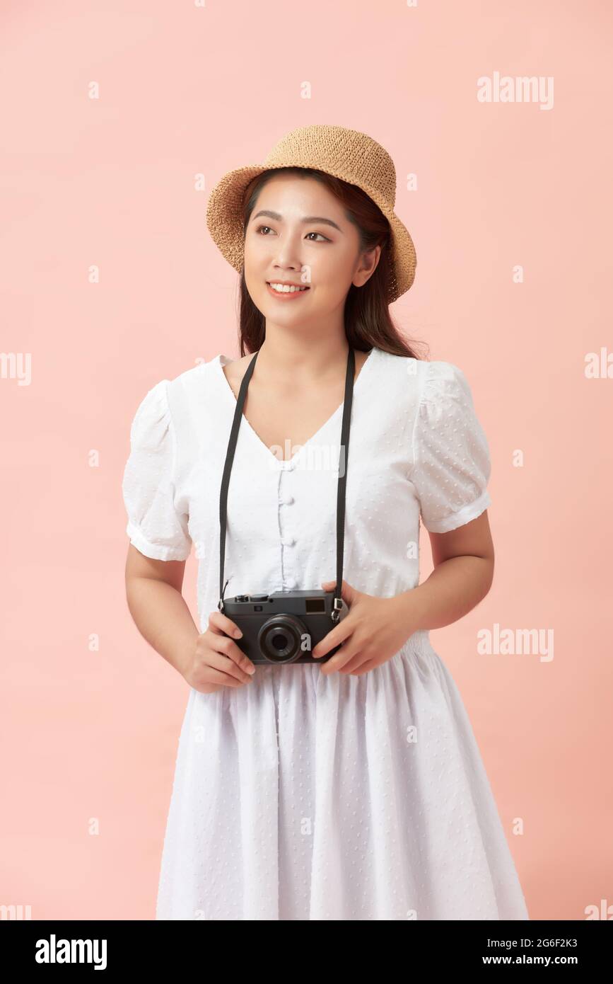 Woman traveler with a camera, pink background Stock Photo - Alamy