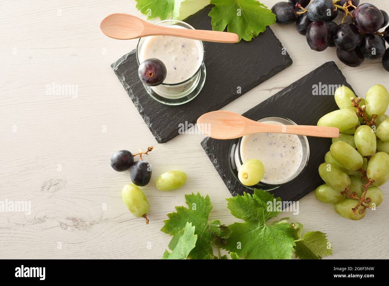 Organic grape drink on slate plates with bunches of white and red ...